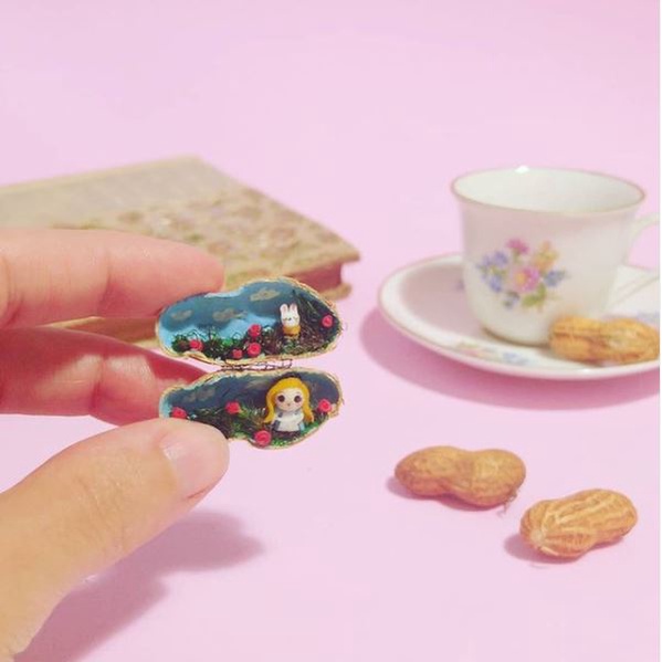 Miniatura da Alice no País das Maravilhas dentro da casca de amendoim ...